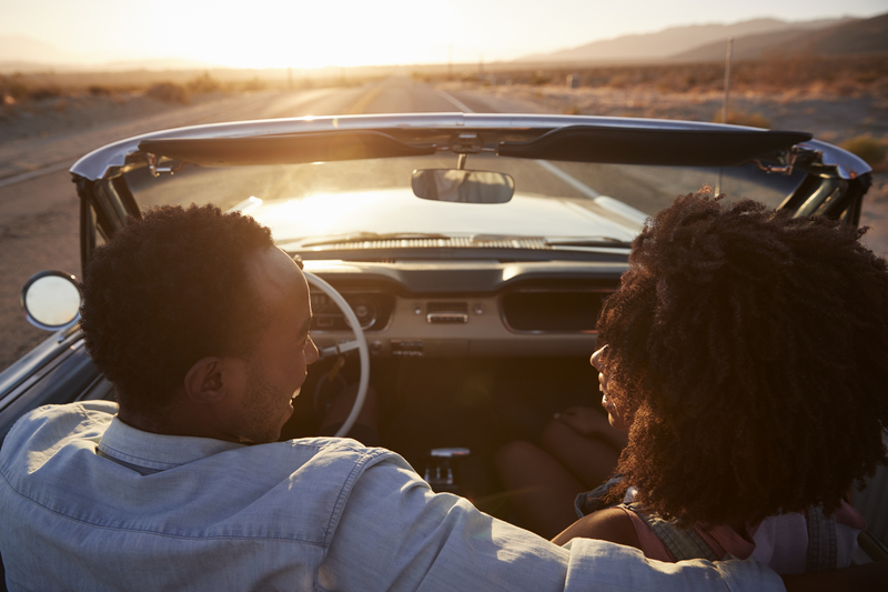 Rear View Of Couple On Road Trip Driving Classic Convertible Car ...